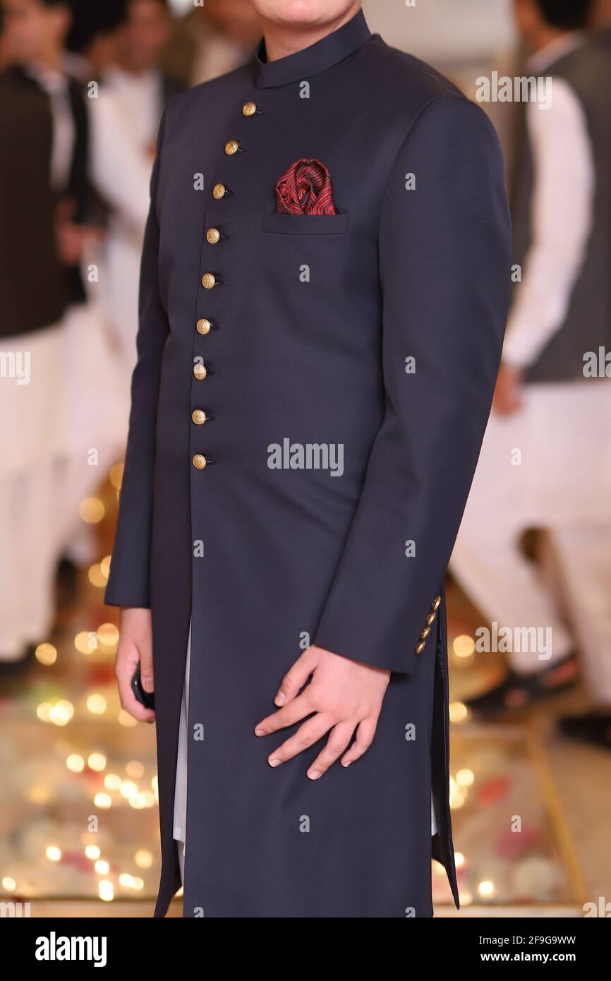 A young man wearing a Pakistani traditional dress red pocket square ...
