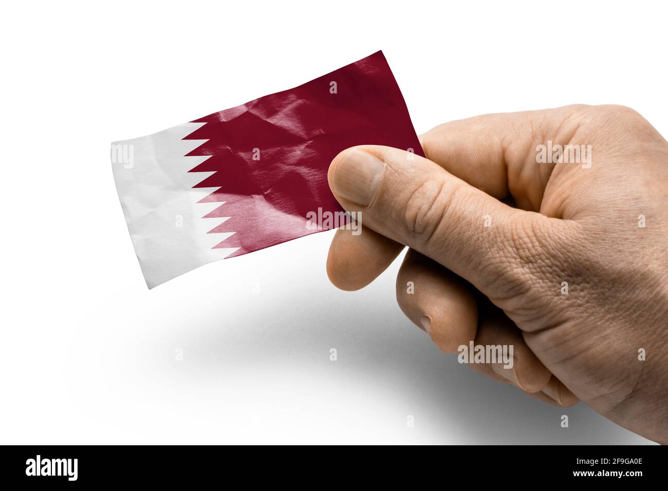Hand holding a card with a national flag the Qatar Stock Photo - Alamy