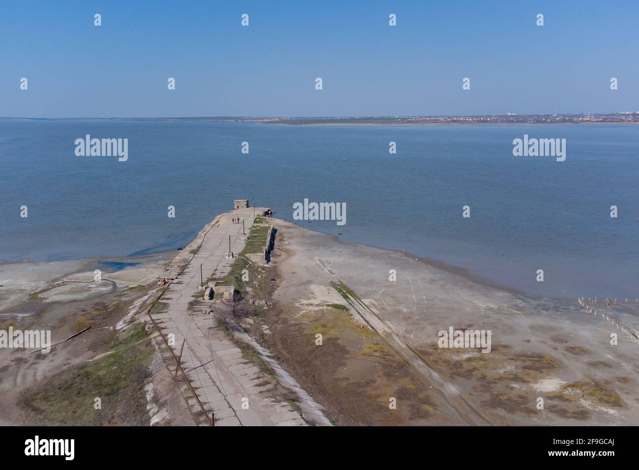 A stone spit and wooden pillars on the surface of the Kuyalnik estuary ...
