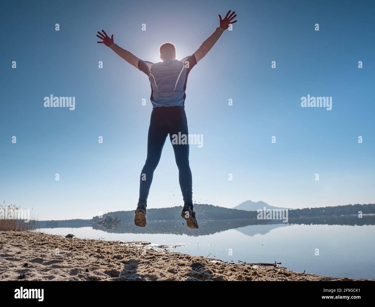 Man jumping on the beach at sunset. Funny happy man jumps in the air ...