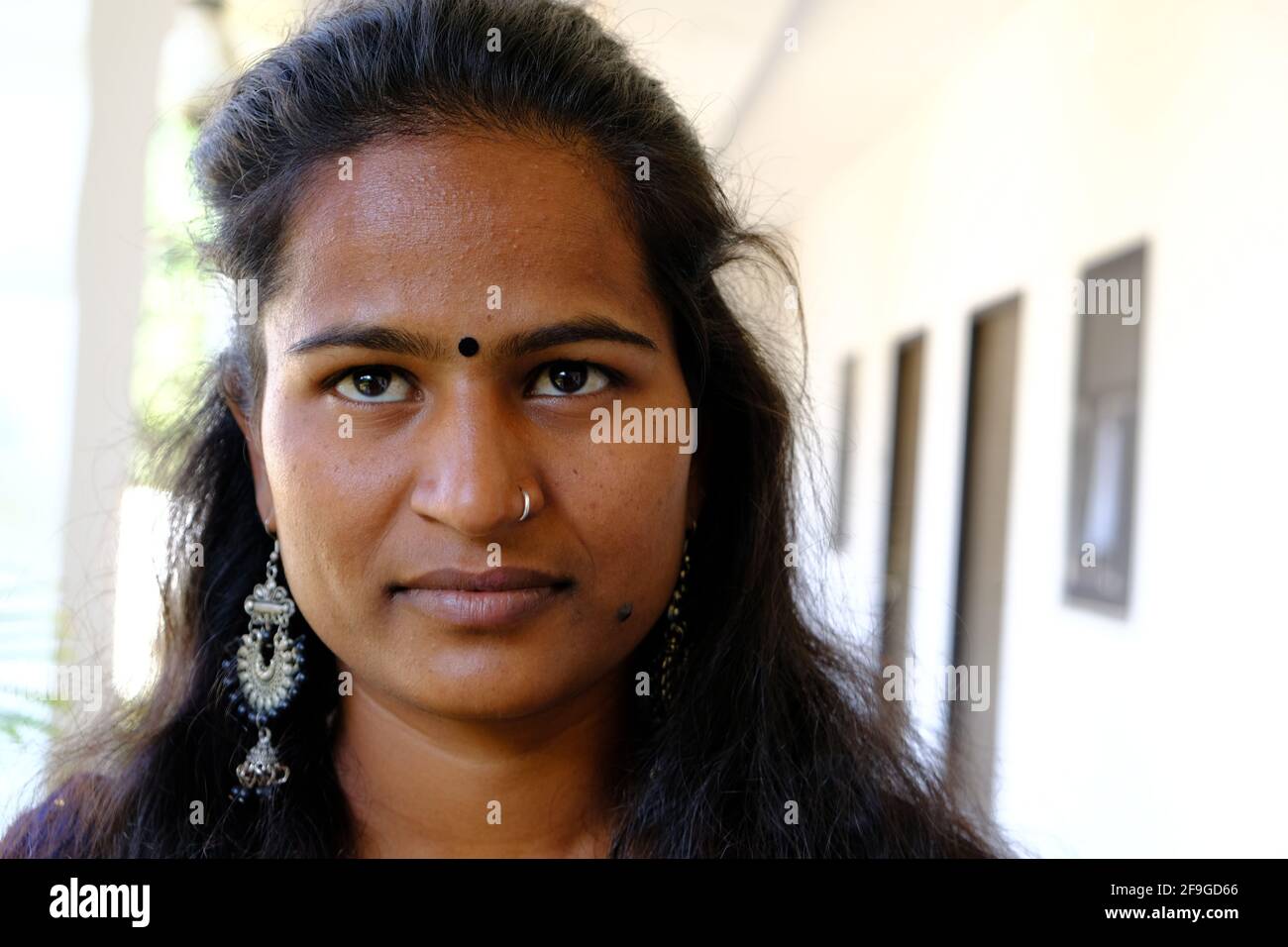 A closeup portrait of a young Indian woman with a bindi on her forehead ...