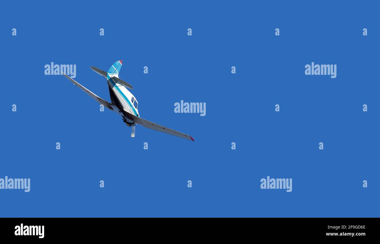 small single-propeller airplane flies in the clear blue sky flying high ...