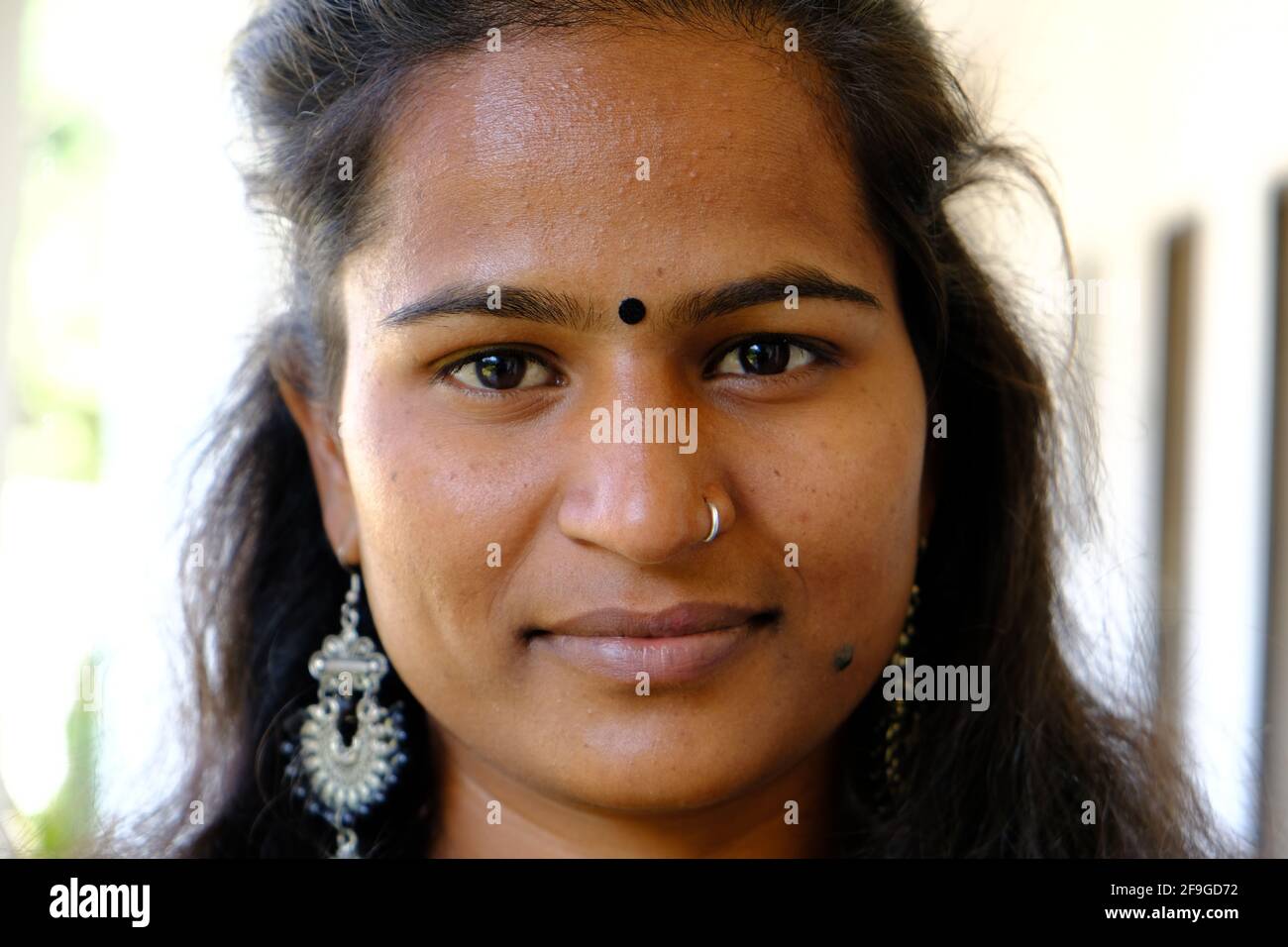 A closeup portrait of a young Indian woman with a bindi on her forehead ...