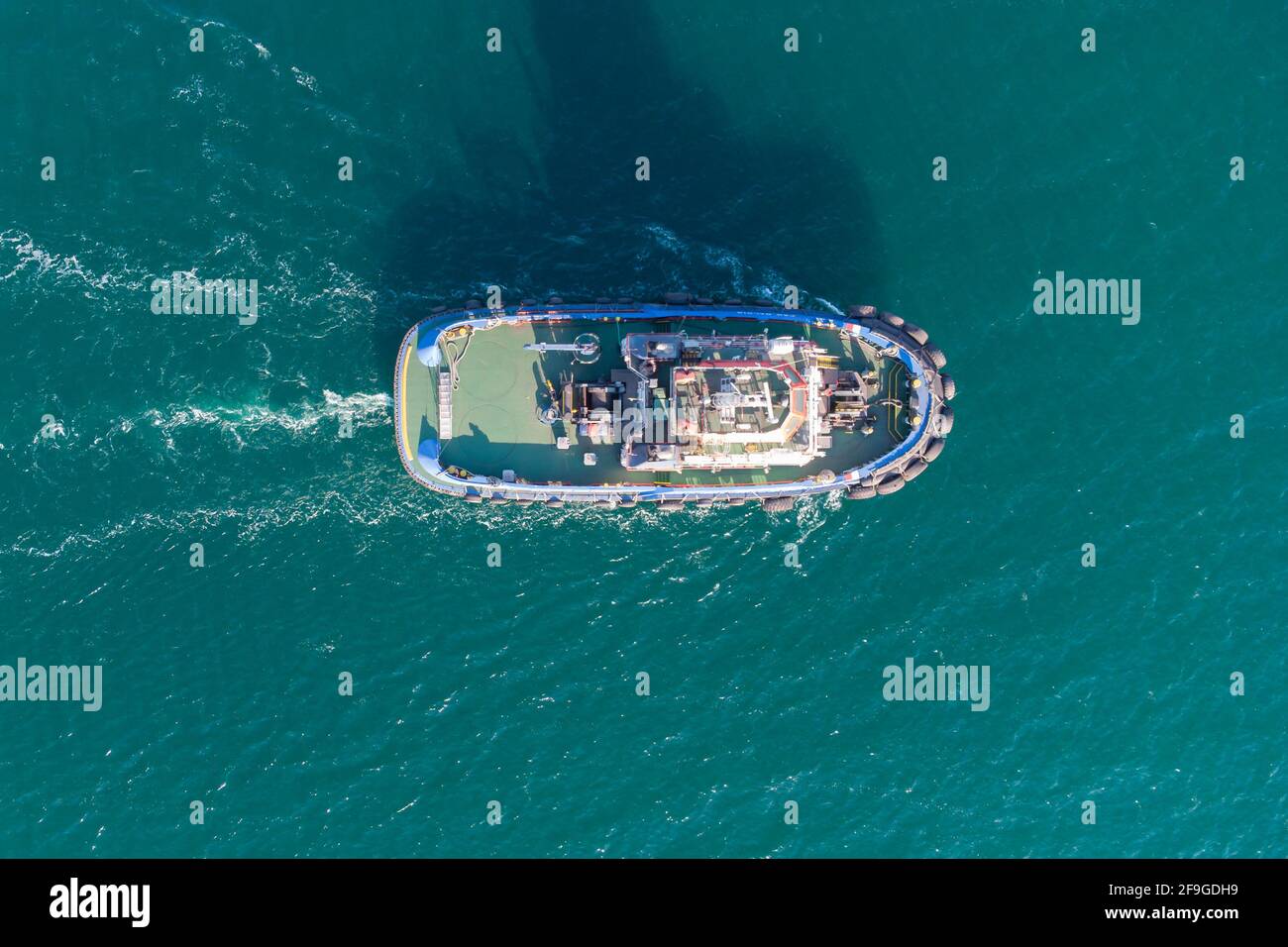 The sea tug moves from the port water area towards the open sea. Photo ...