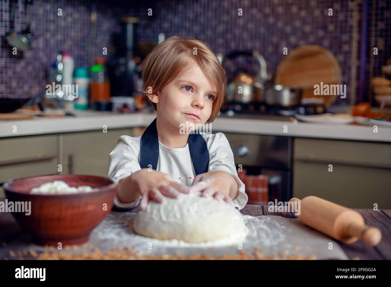 Little child girl with short hair haircut cooking dough Stock Photo - Alamy