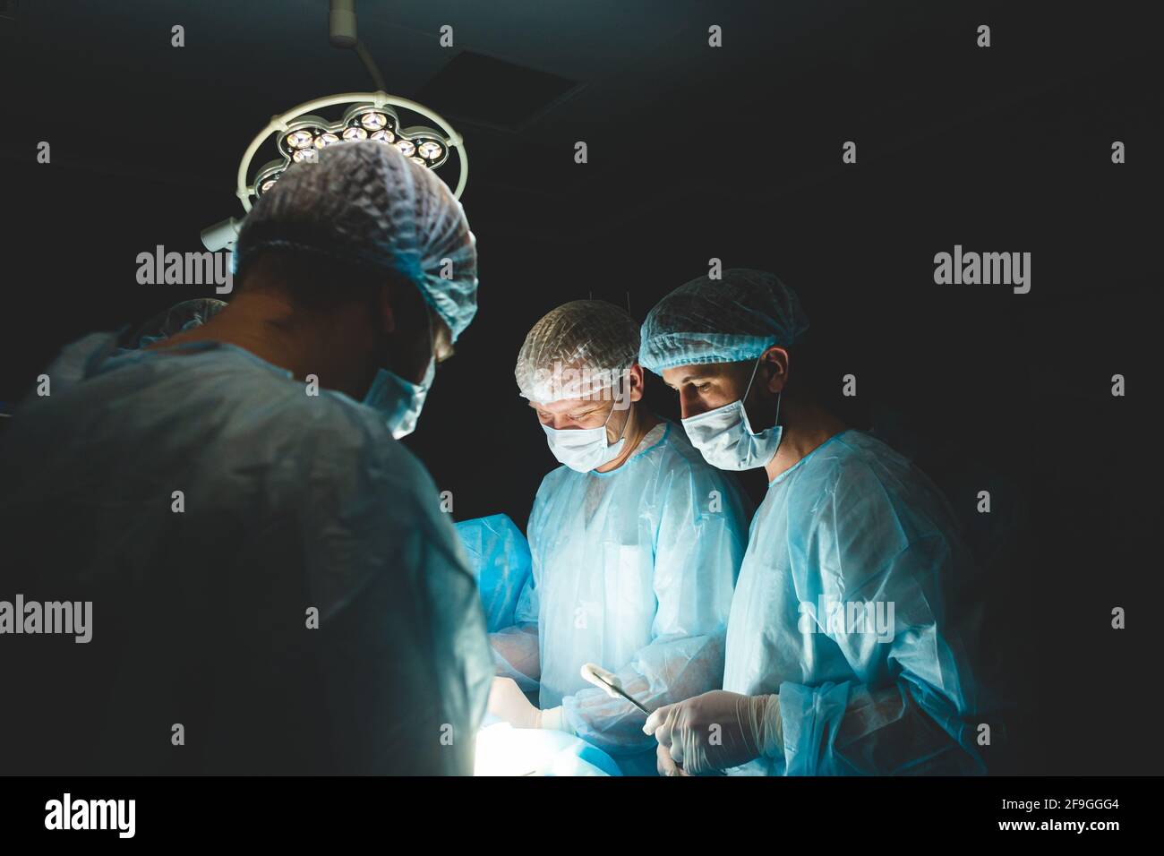 An international team of doctors performs a complex surgical operation ...