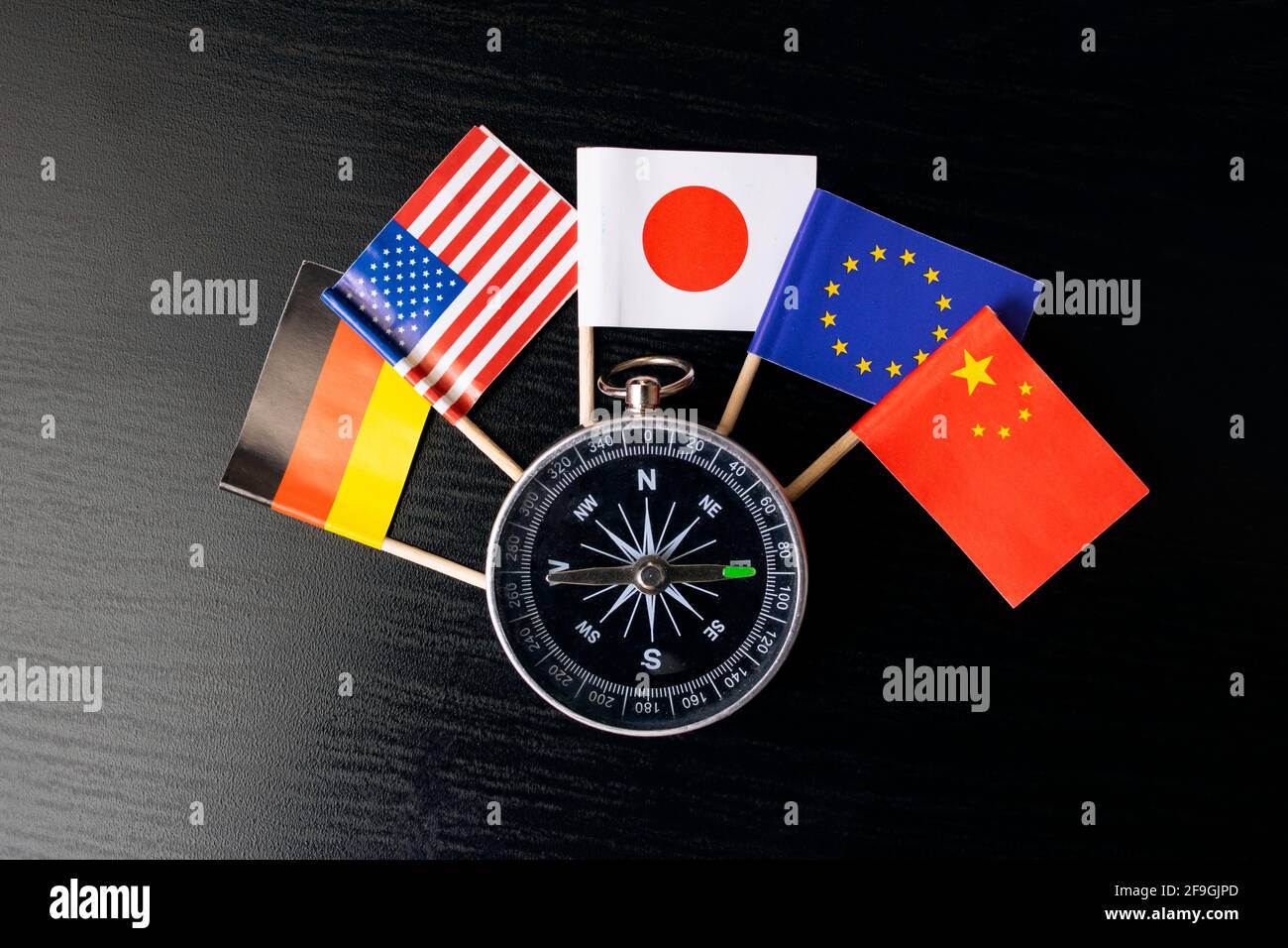 Compass and flags of countries on wooden table, travel concept Stock ...