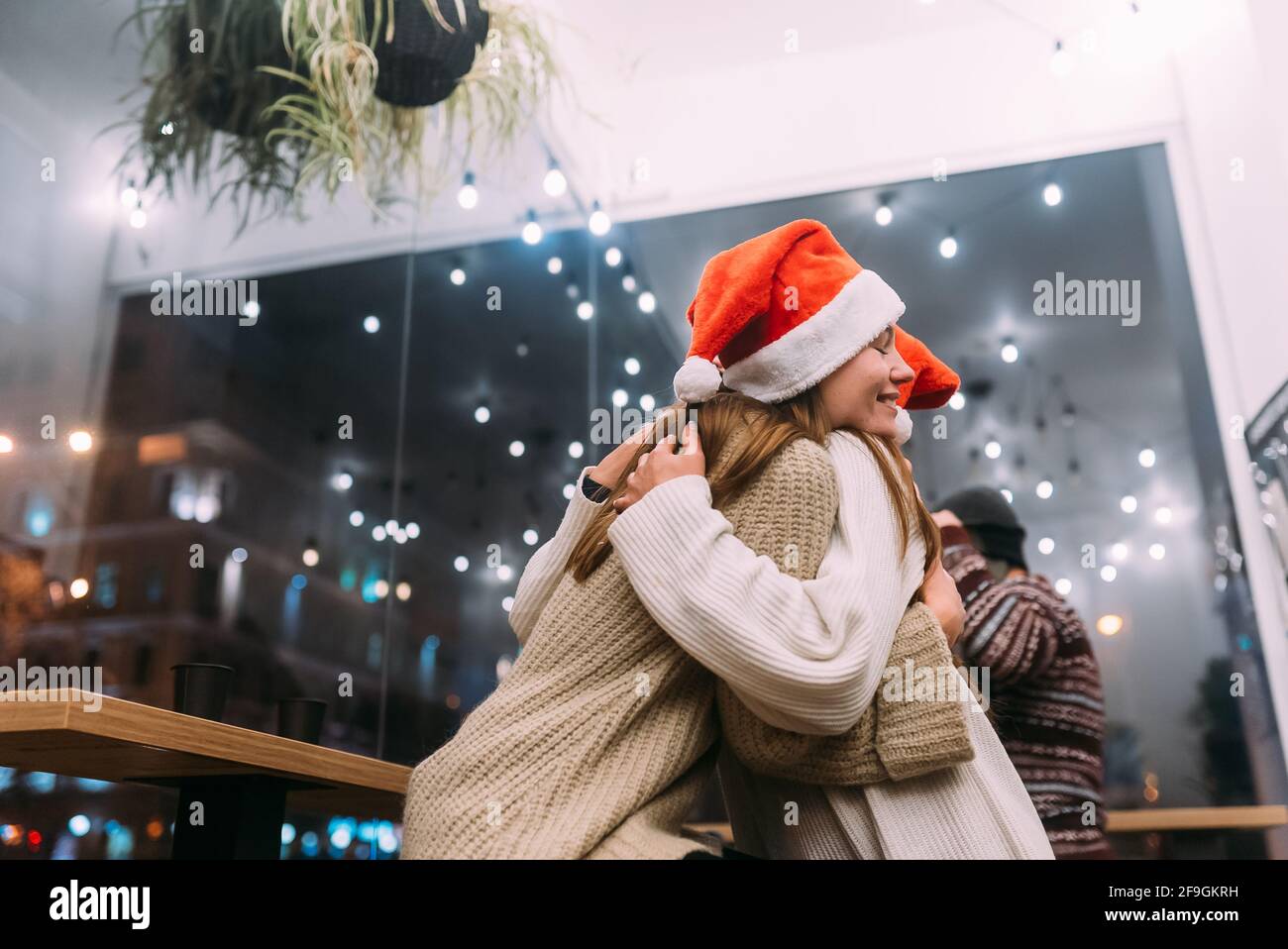Portrait of happy cute young friends hugging each other at caffe Stock ...