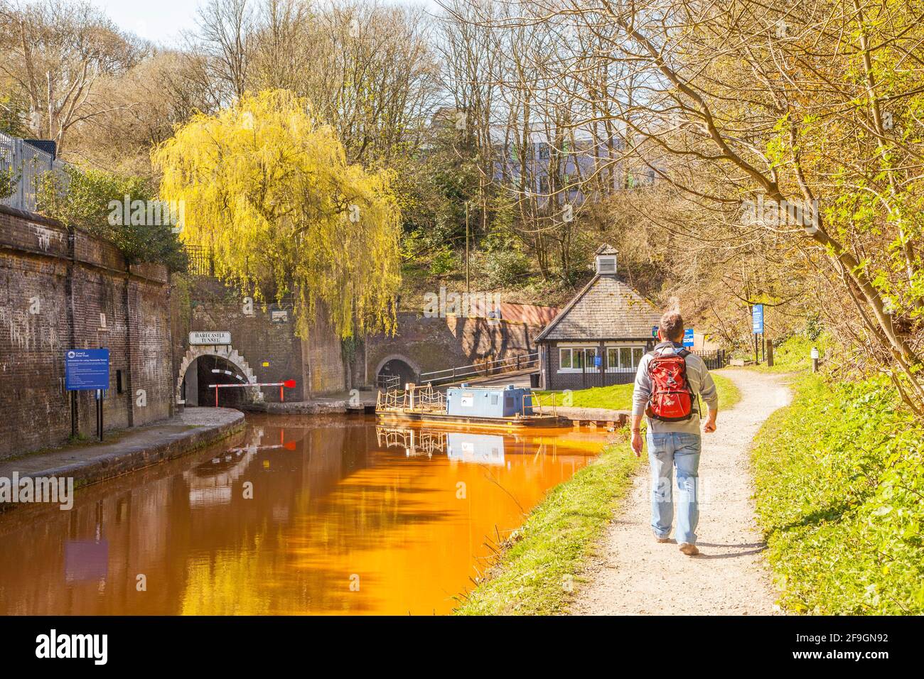 Man walking along the canal towpath of the Trent and Mersey canal ...