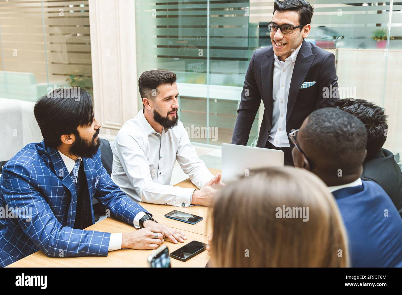 A team of young office workers, businessmen with laptop working at the ...