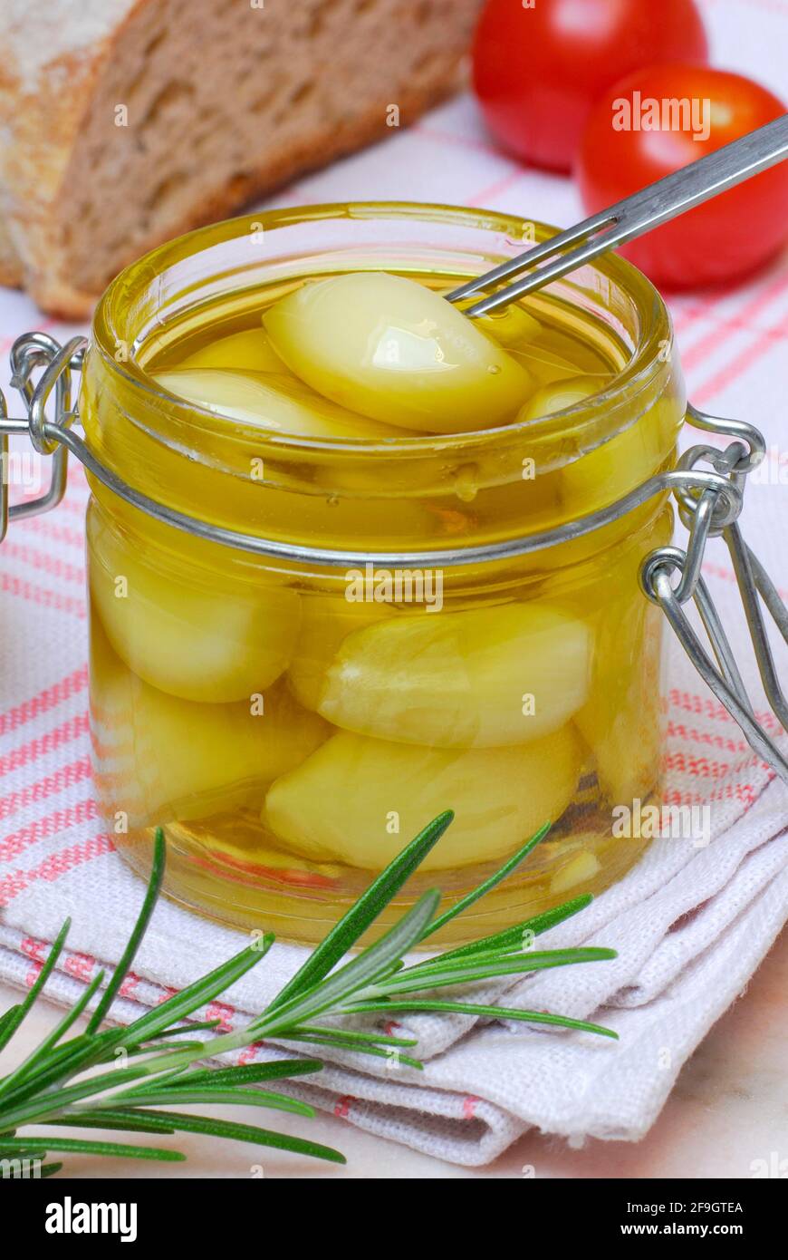 Garlictoes (Allium sativum) in olive oil, with rosemary Stock Photo - Alamy