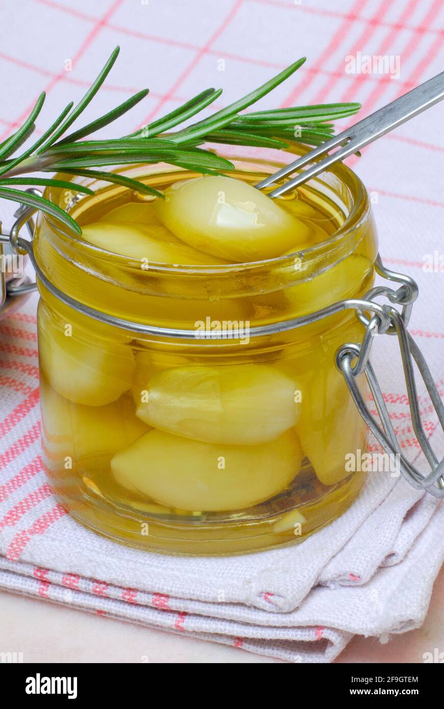 Garlictoes (Allium sativum) in olive oil, with rosemary Stock Photo - Alamy