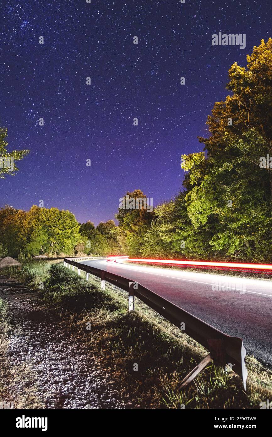 A mysterious englightend road at the night with starry sky Stock Photo ...
