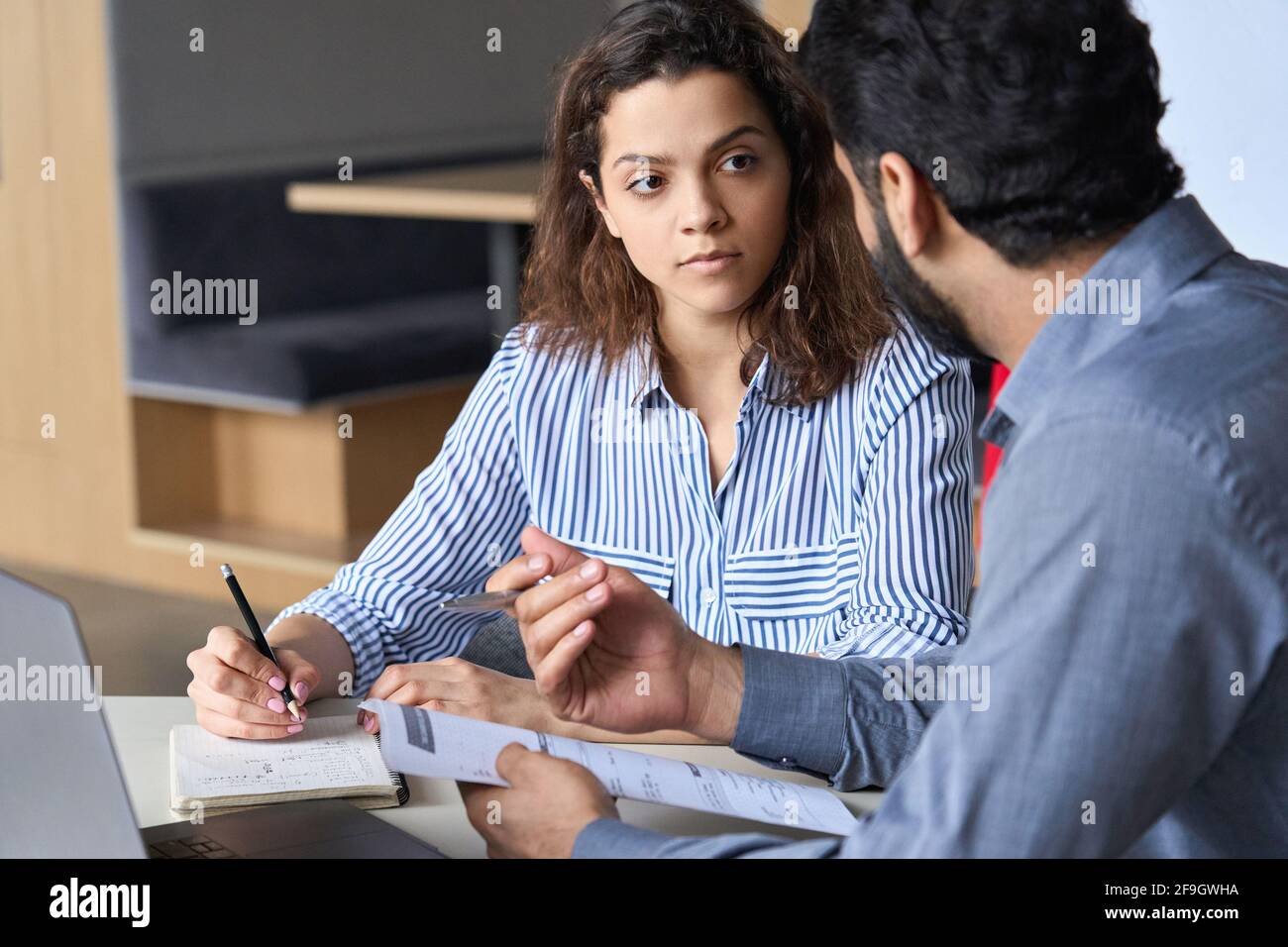 Mentoring Hispanic teacher and latin student working together on course ...