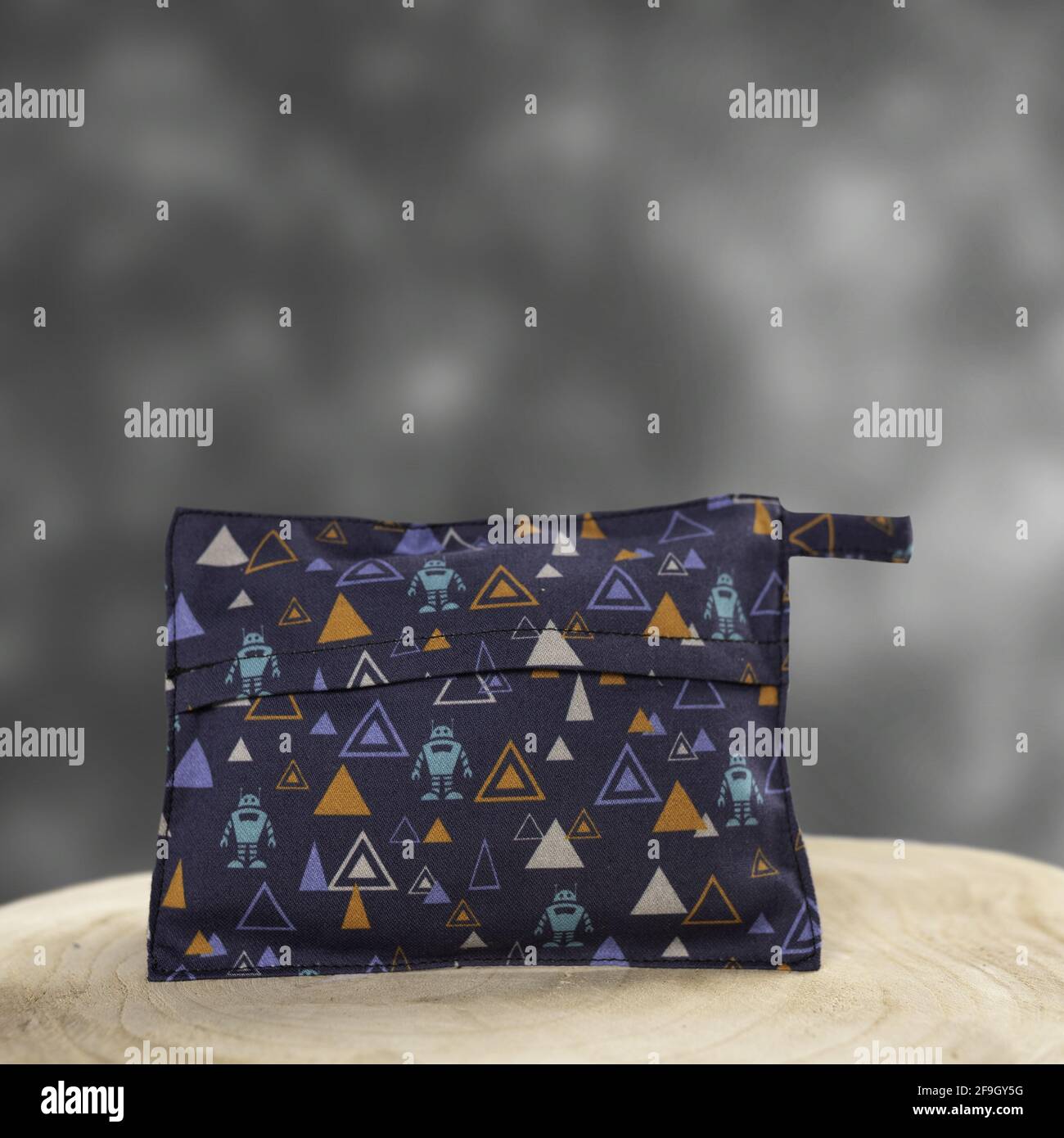 A hygiene pouch with geometric print, displayed on a wooden disc Stock ...