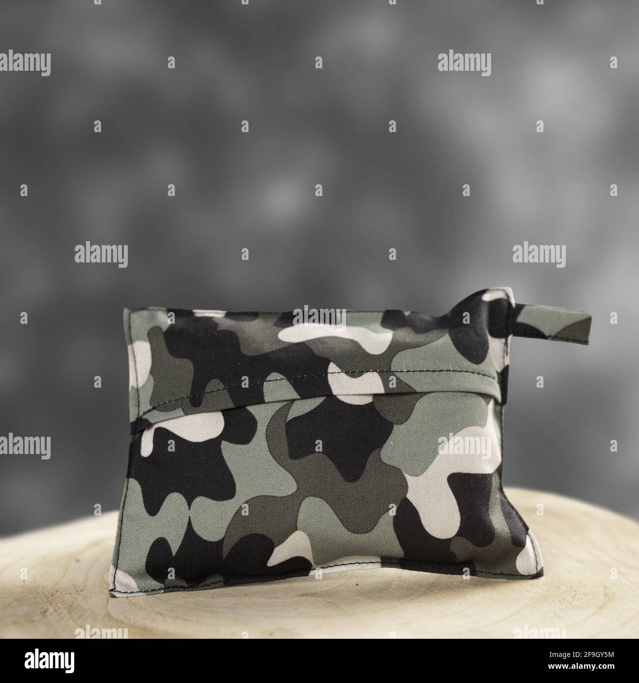 A hygiene pouch with camouflage print, displayed on a wooden disc Stock ...