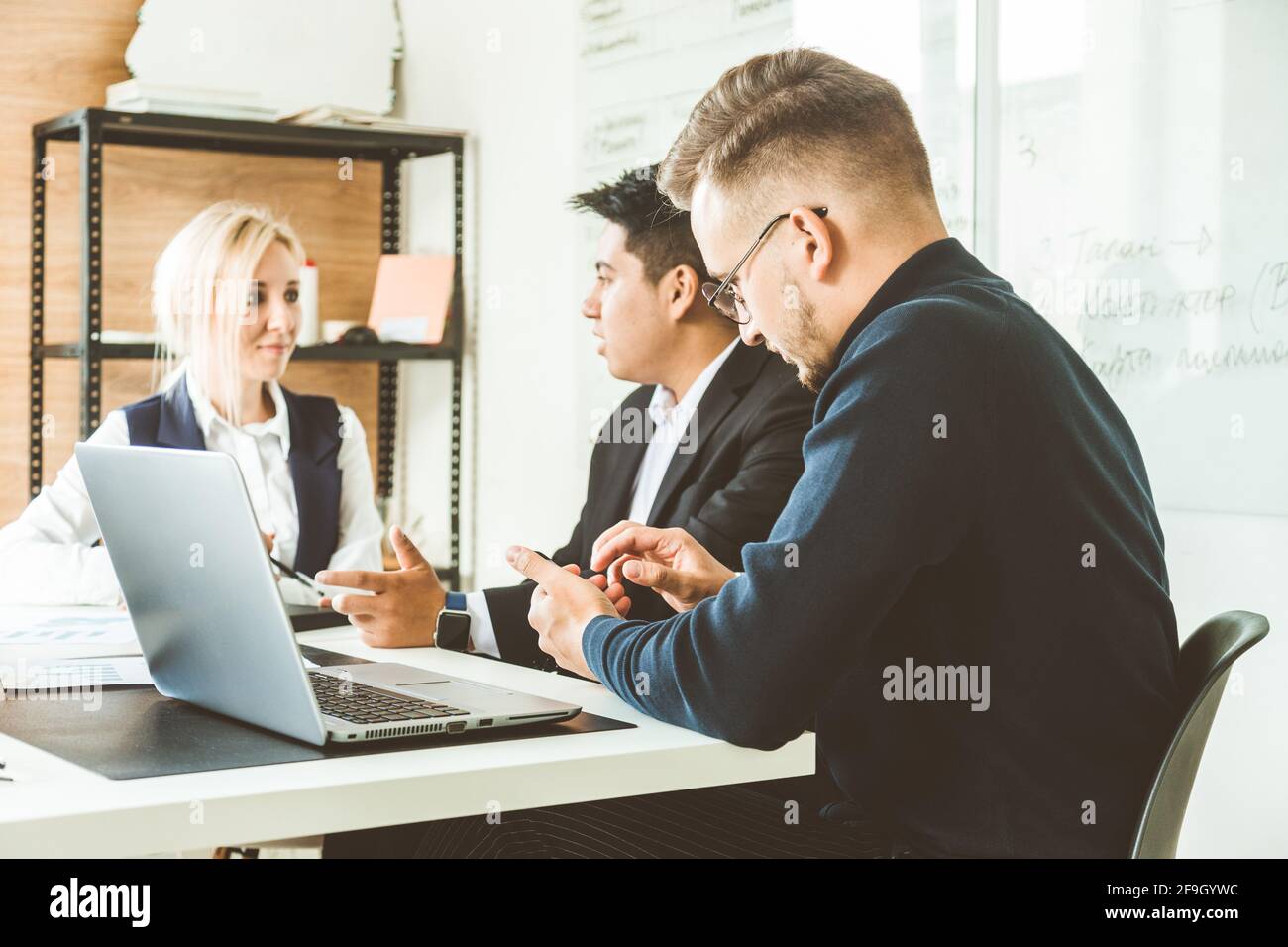 A team of young businessmen working and communicating together in an ...