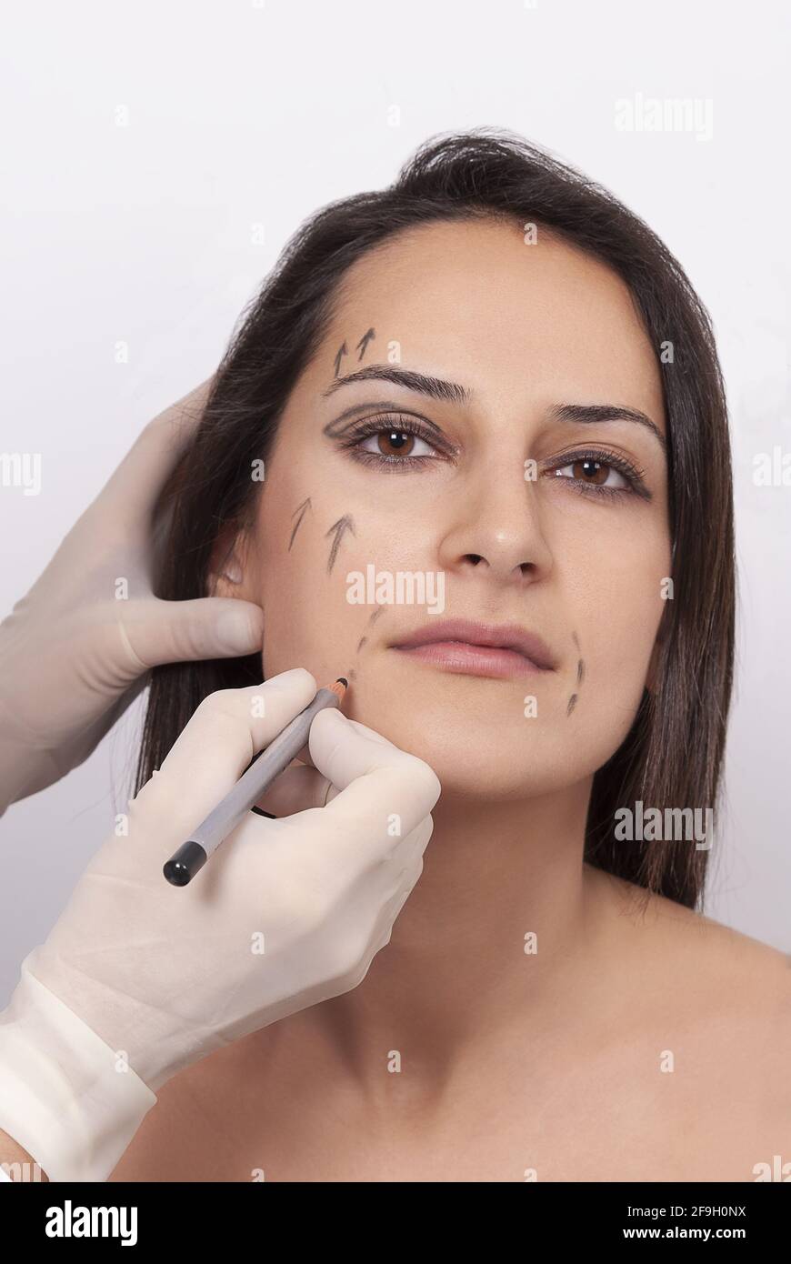 A vertical closeup shot of a woman preparing her face for a plastic ...