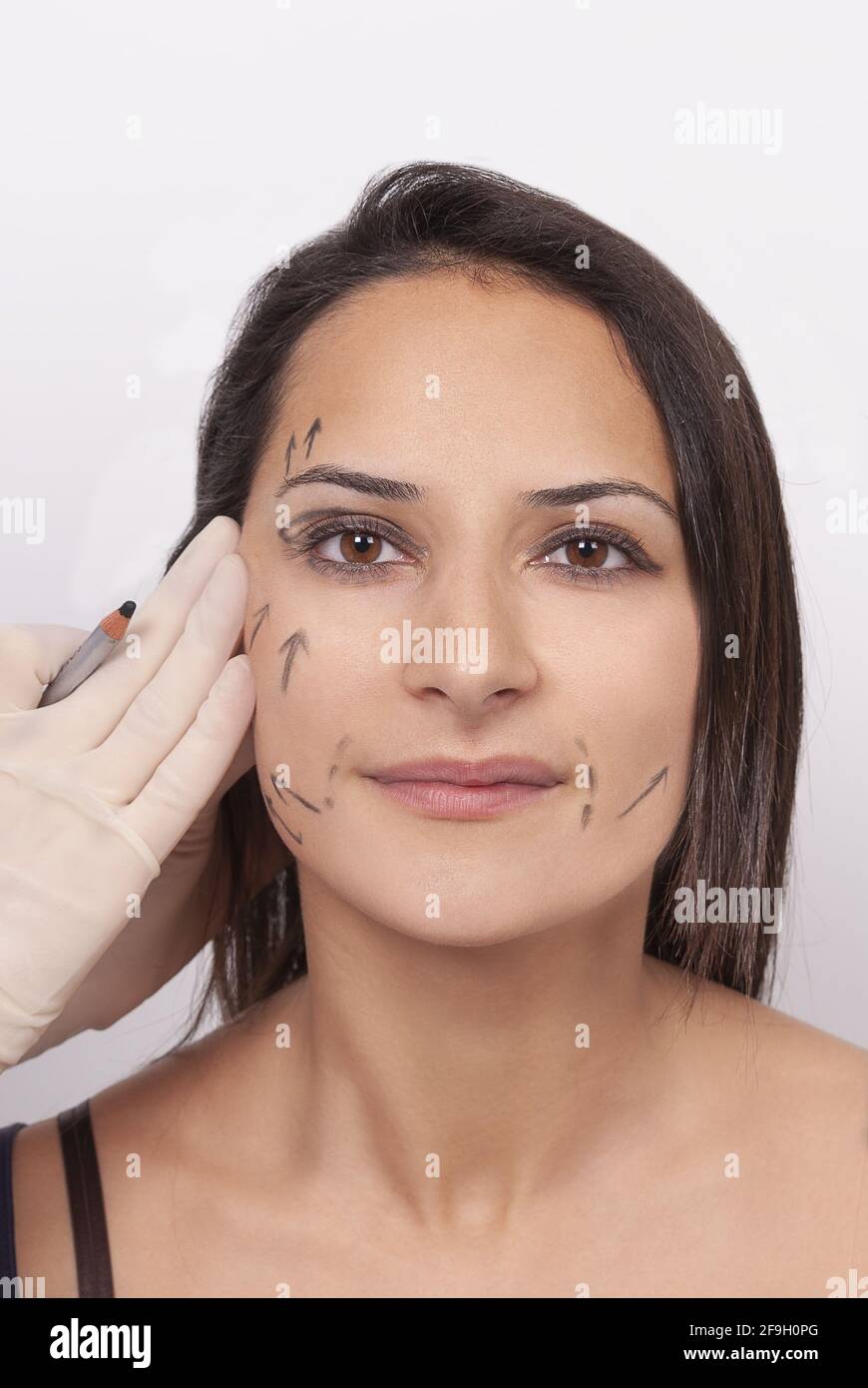 A vertical closeup shot of a woman preparing her face for a plastic ...