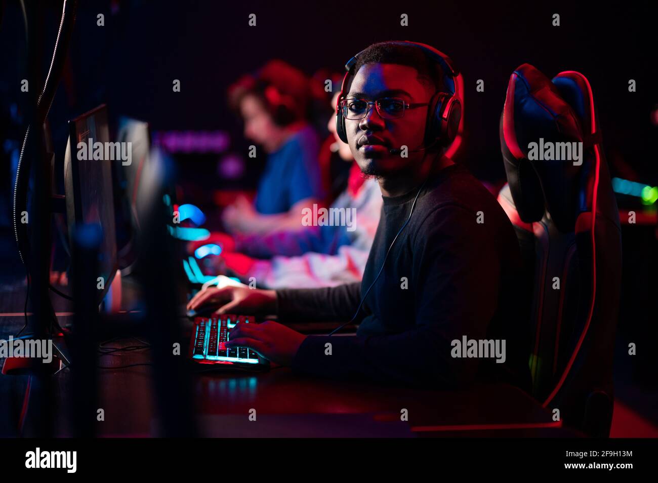 Portrait of a black gamer with glasses sitting in a computer gaming ...