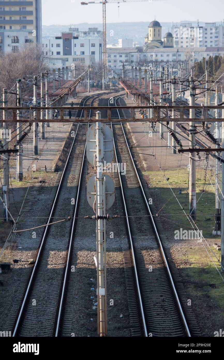 A vertical shot of railways near a train station with buildings on ...