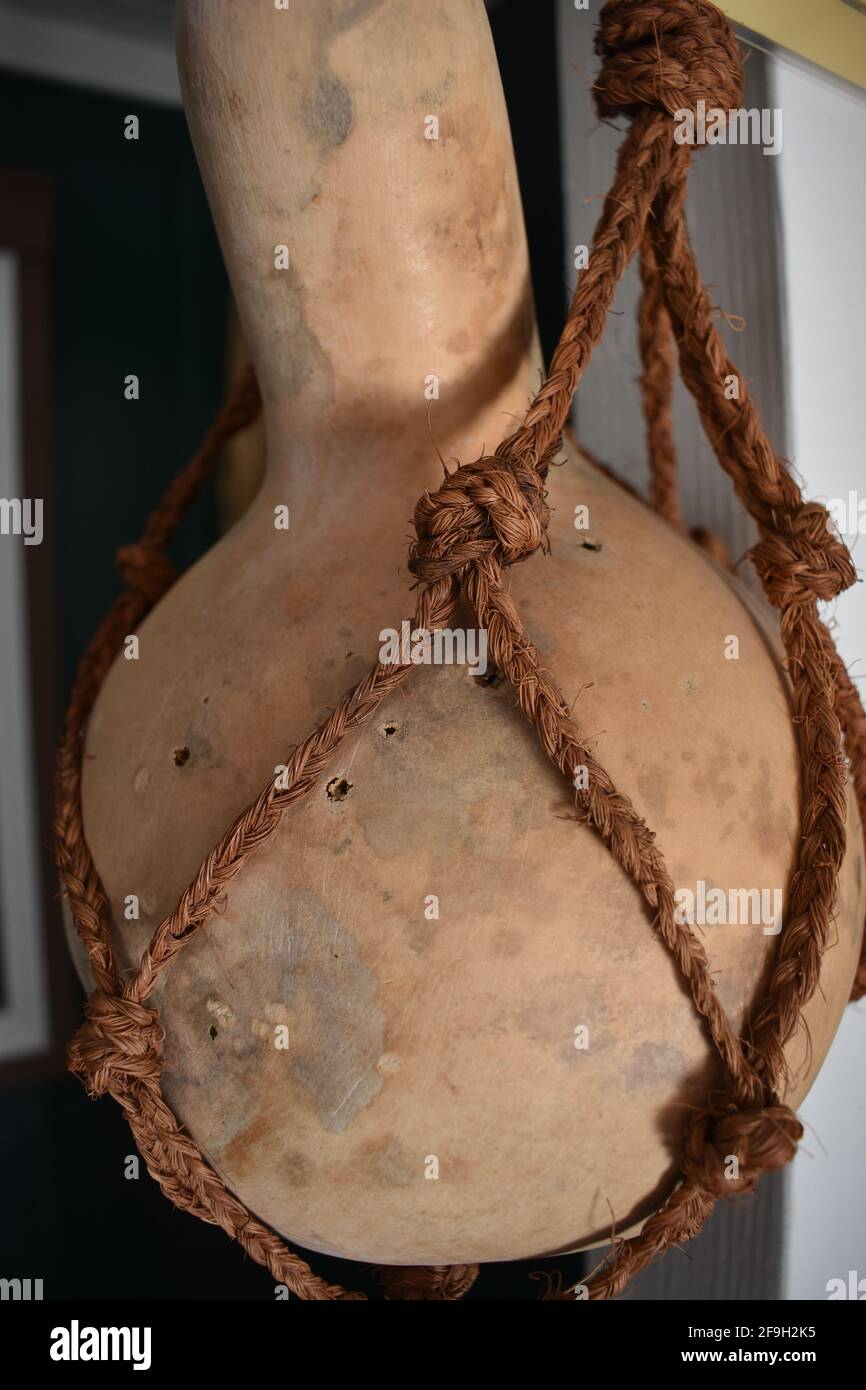 A vertical closeup of an old clay jar hanging on a rope Stock Photo - Alamy