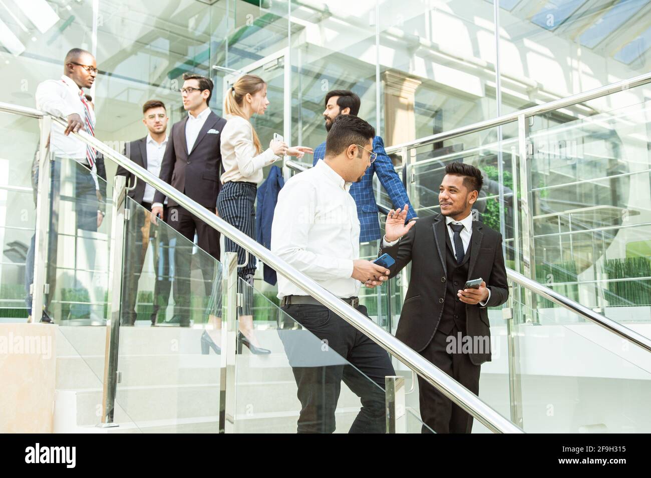 young business people arego down the stairs and talking on the ...