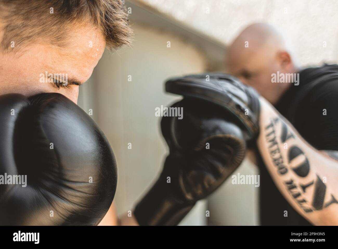 Two men exercising and fighting in outside. Boxer in gloves is training ...