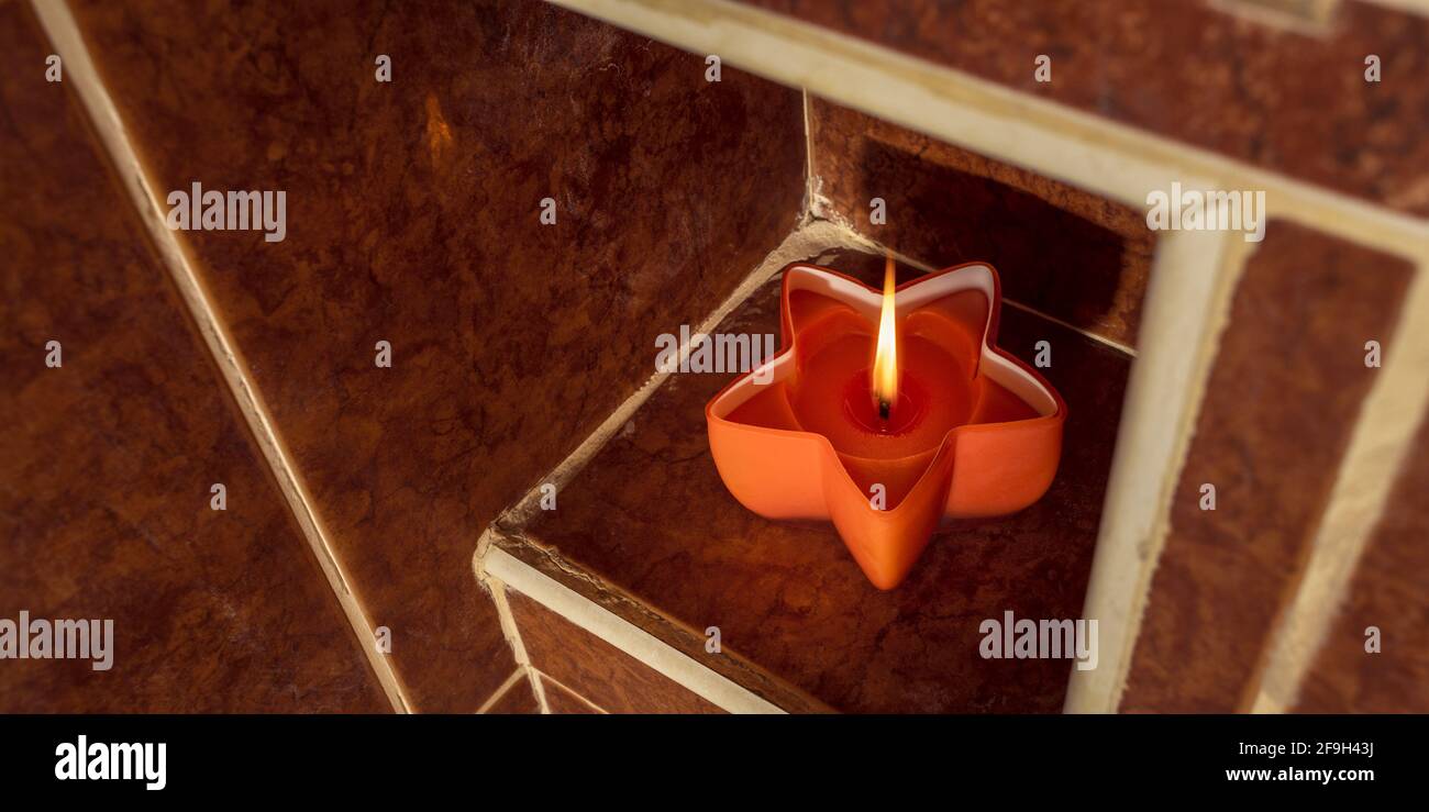 A high angle of a star shaped burning candle on bath tiles Stock Photo ...