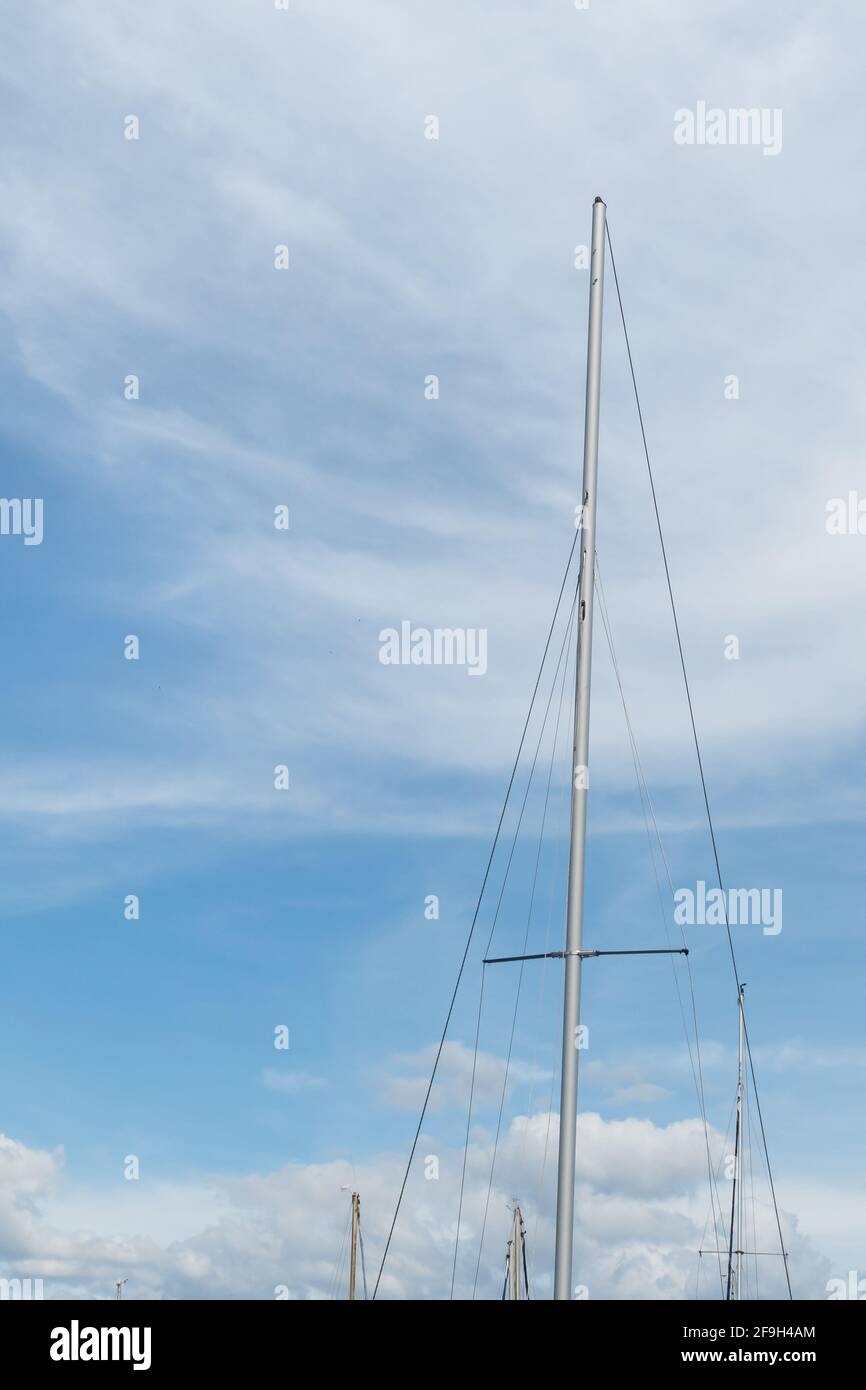 sailboat mast without sail over blue sky with white clouds Stock Photo ...