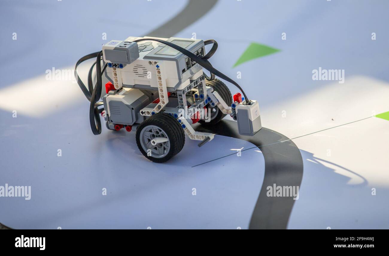 A closeup shot of a mini robot with wheels following the pattern on the ...