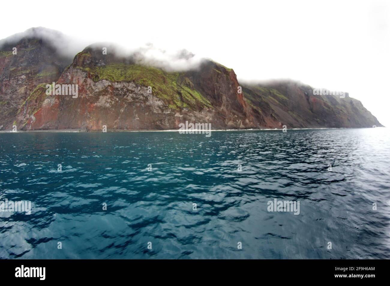 Cloud topped mountains above the bay at Punta Vincente Roca, Isabela ...