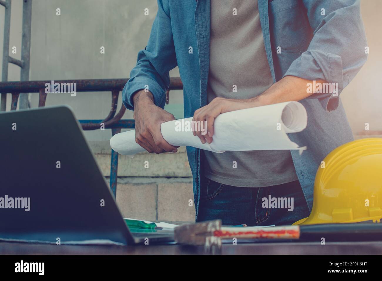 Engineer holding blueprint working on site construction Stock Photo - Alamy