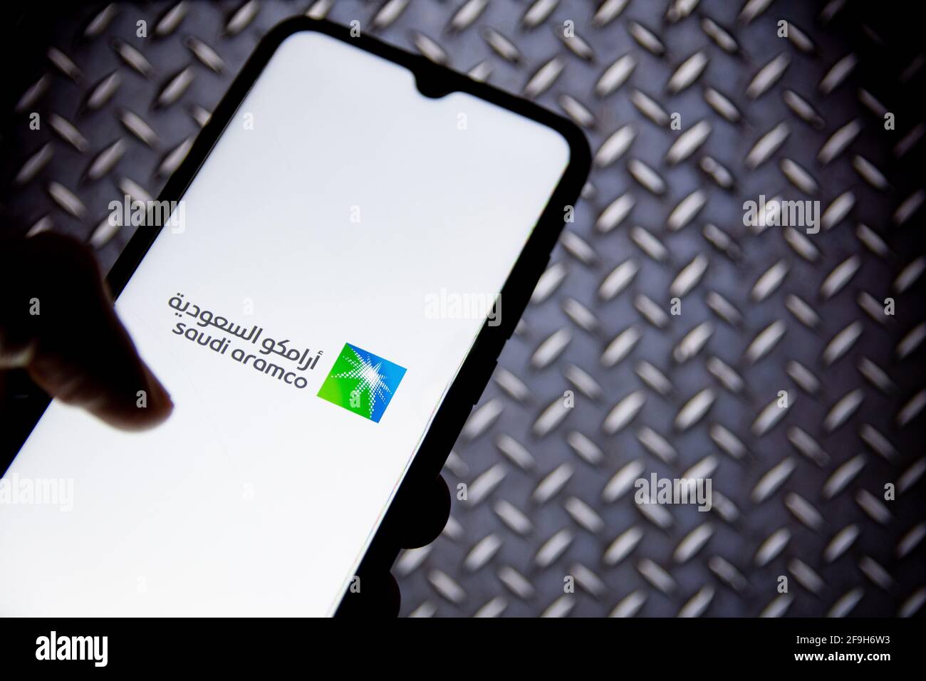 In this photo illustration a Saudi Aramco logo seen displayed on a ...