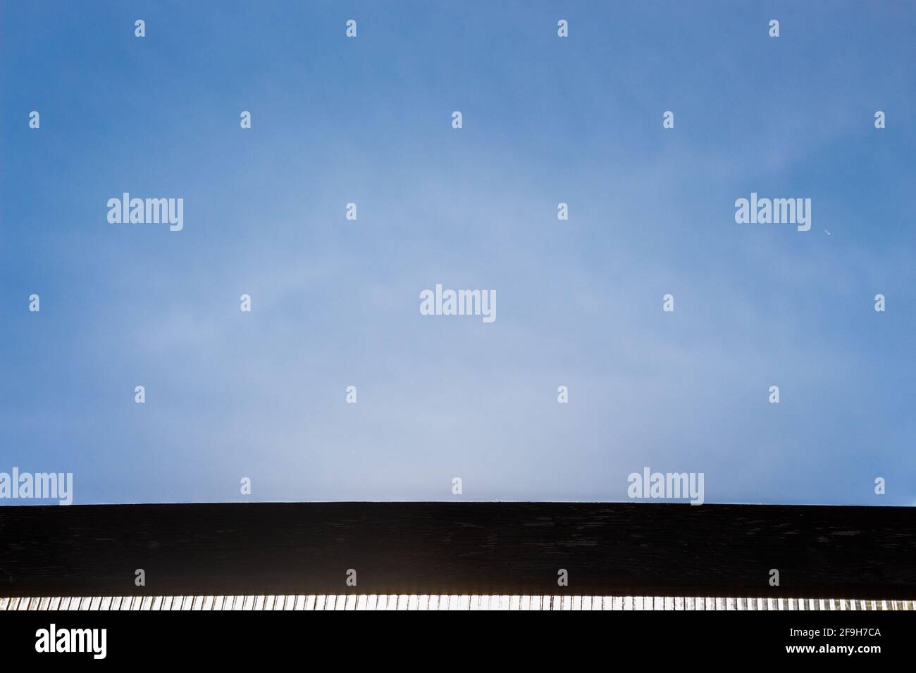 Black horizontal line of a building on a clear blue sky for a ...