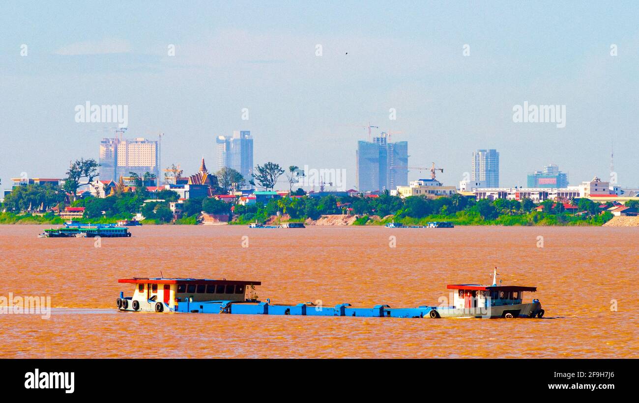 City of Phnom Penh, a boat and a ship barge in the polluted water in ...