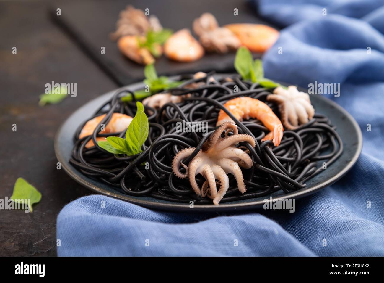 Black cuttlefish ink pasta with shrimps or prawns and small octopuses ...