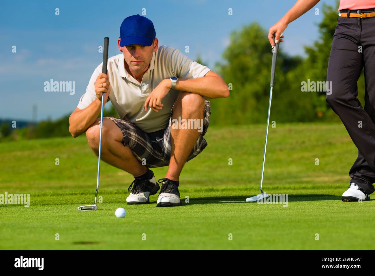 Young golf player on course putting, he aiming for his put shot Stock ...