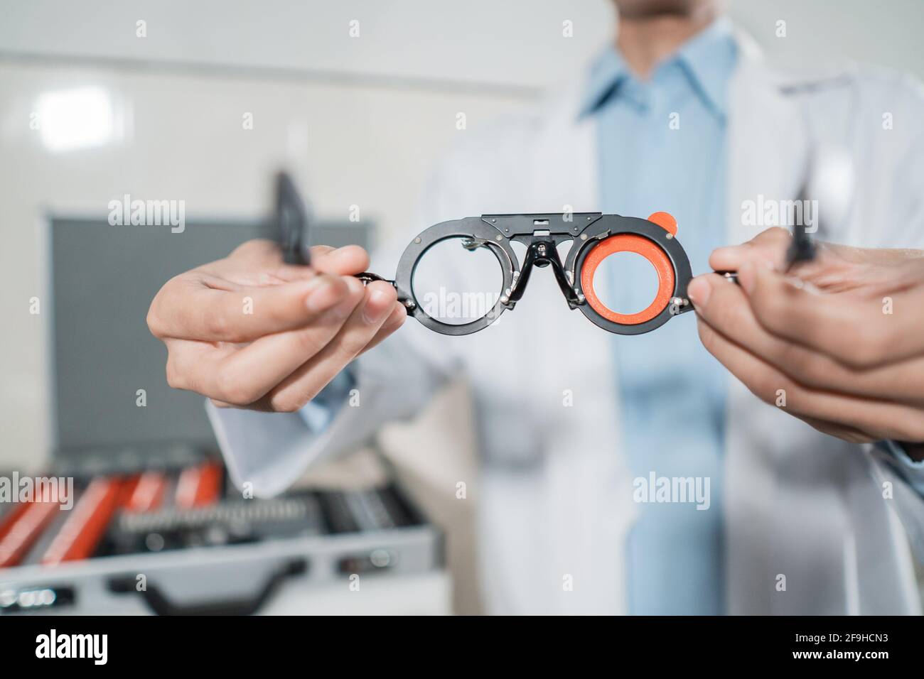 an adjustable axis trial frame is being held by a doctor in an eye ...