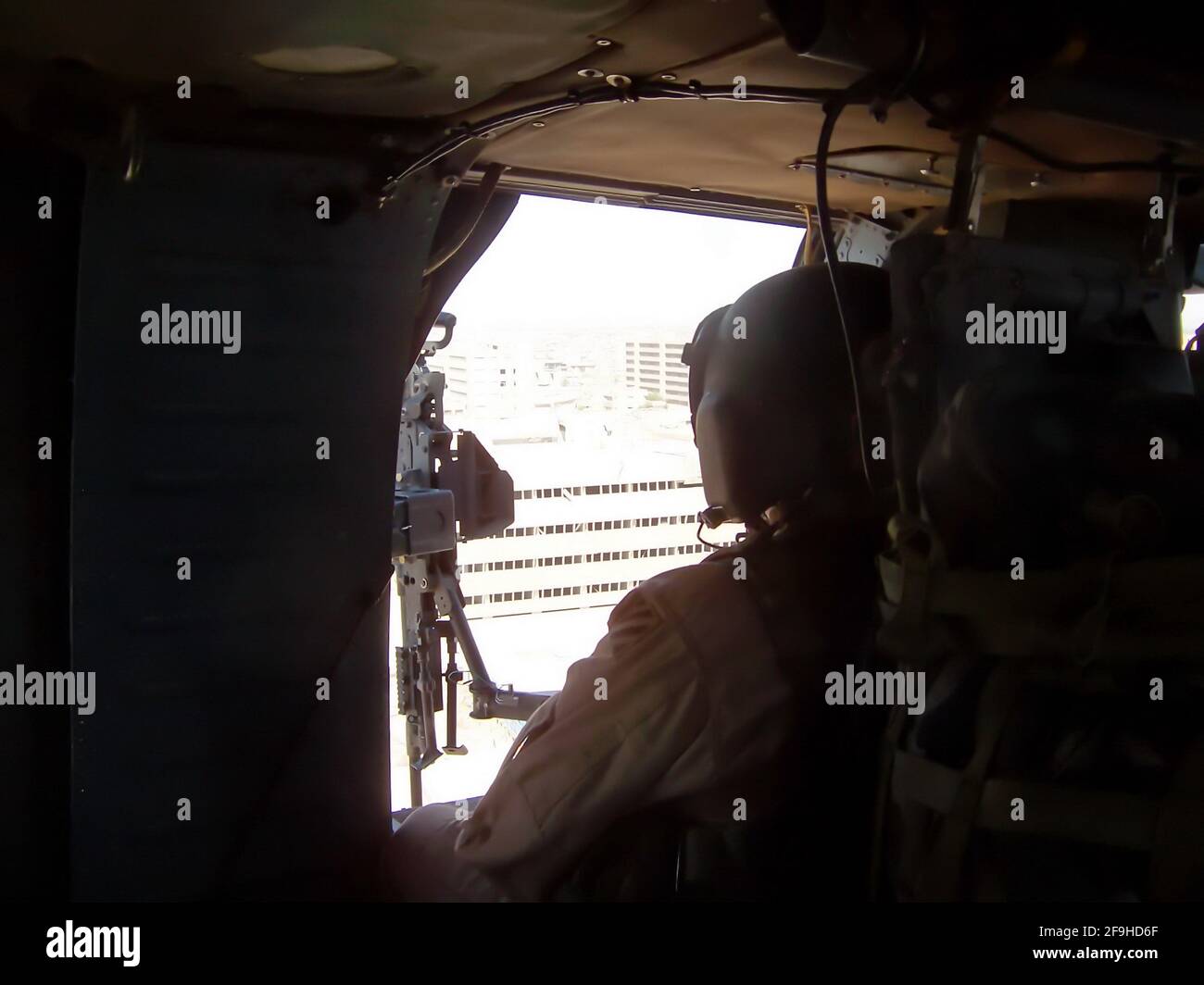 Silhouette of a door gunner in a Blackhawk helicopter above a Forward ...
