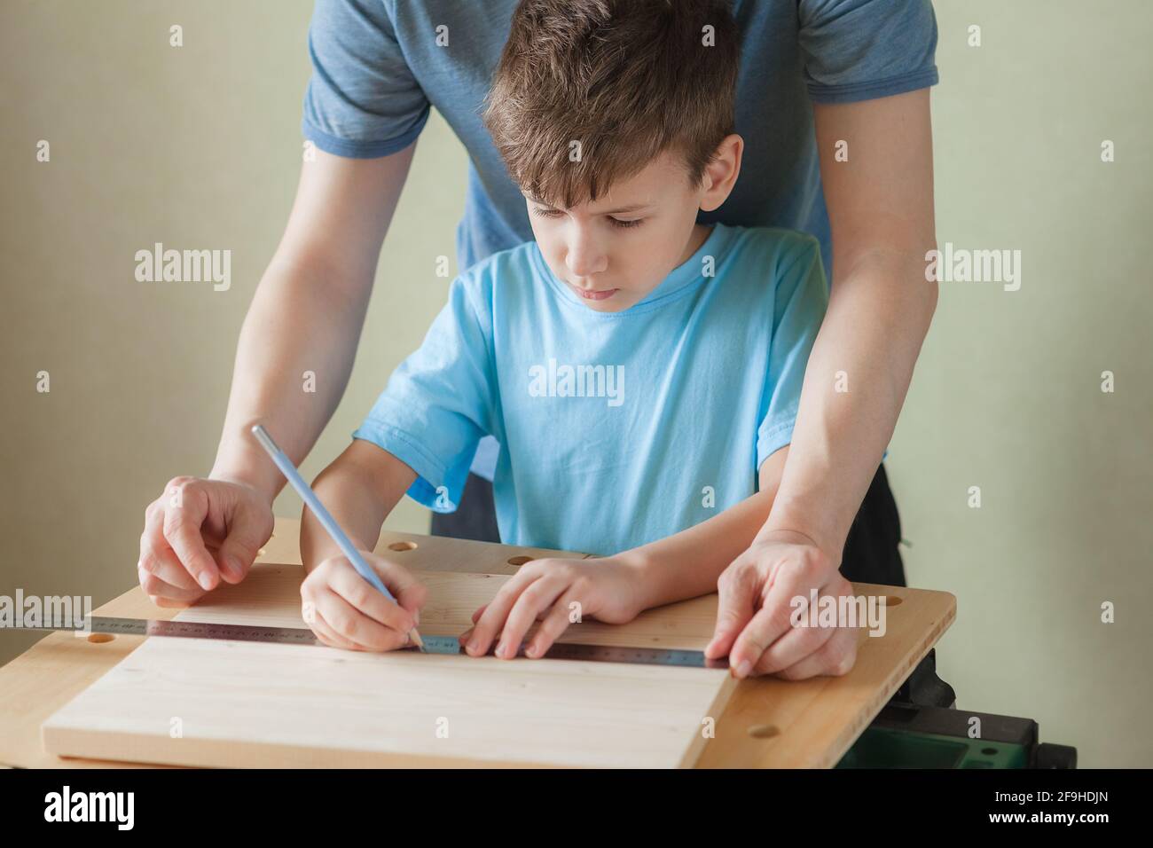 Father teaches son carpentry. Cute little boy with pencil in hand ...
