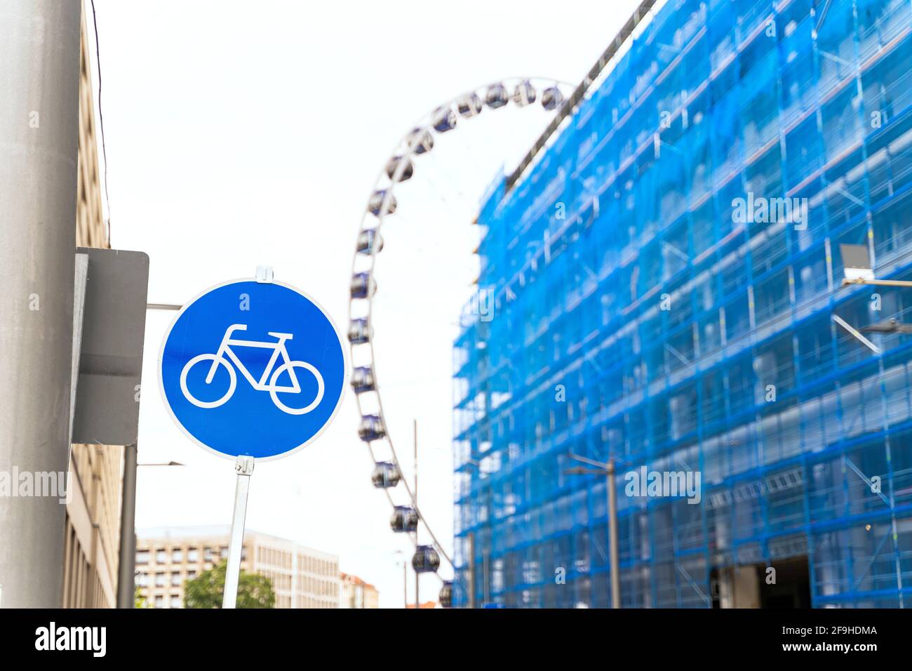 Ferris wheel stands next to a building construction site near road ...