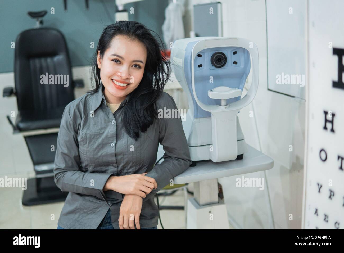 a female doctor posing next to an eye test kit located in an ...