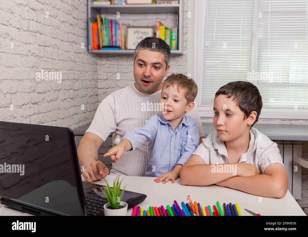 Dad and sons enjoy video conferencing at home. Video call application ...