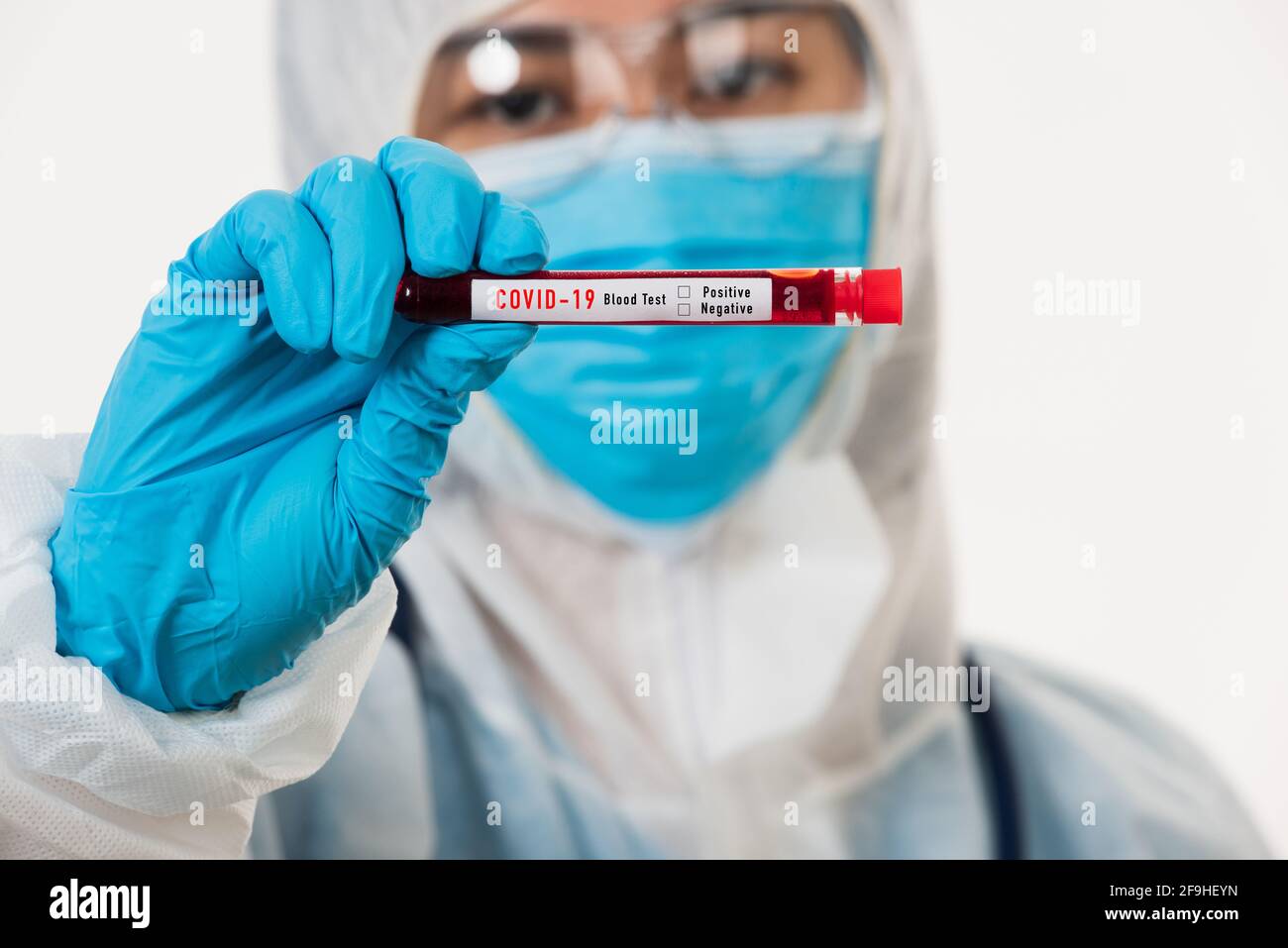 Medical scientist in PPE uniform wear a mask holding test tube ...