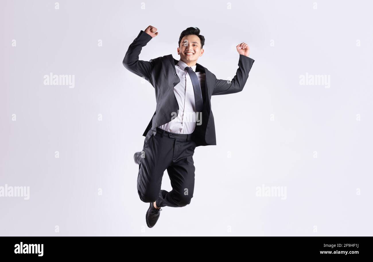 Young Asian businessman jumping on white background Stock Photo - Alamy
