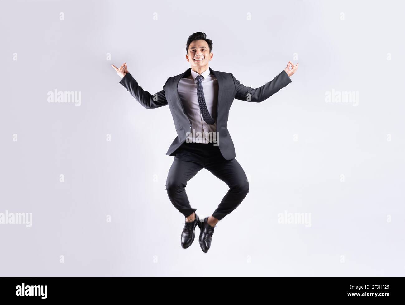 Young Asian businessman jumping on white background Stock Photo - Alamy