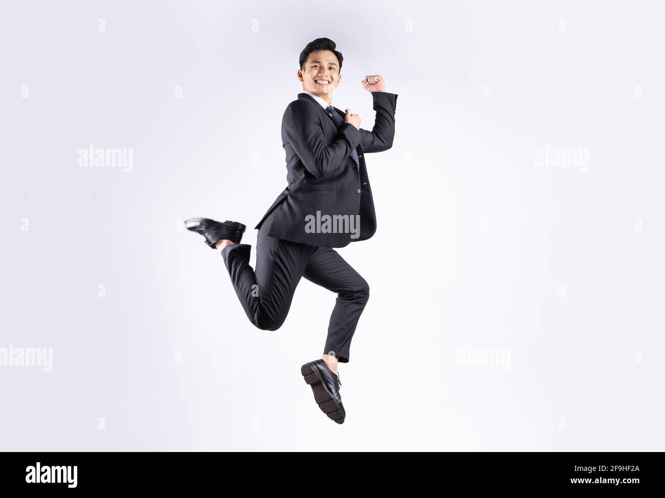 Young Asian businessman jumping on white background Stock Photo - Alamy