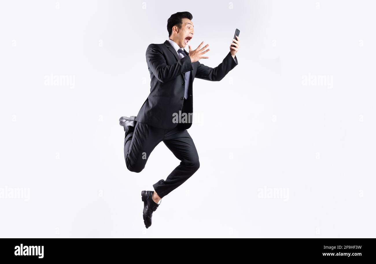 Young Asian businessman jumping on white background Stock Photo - Alamy