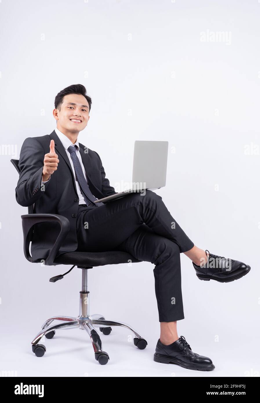 Young Asian businessman sitting on chair on white background Stock ... Young Asian businessman sitting on chair on white background Stock ...
